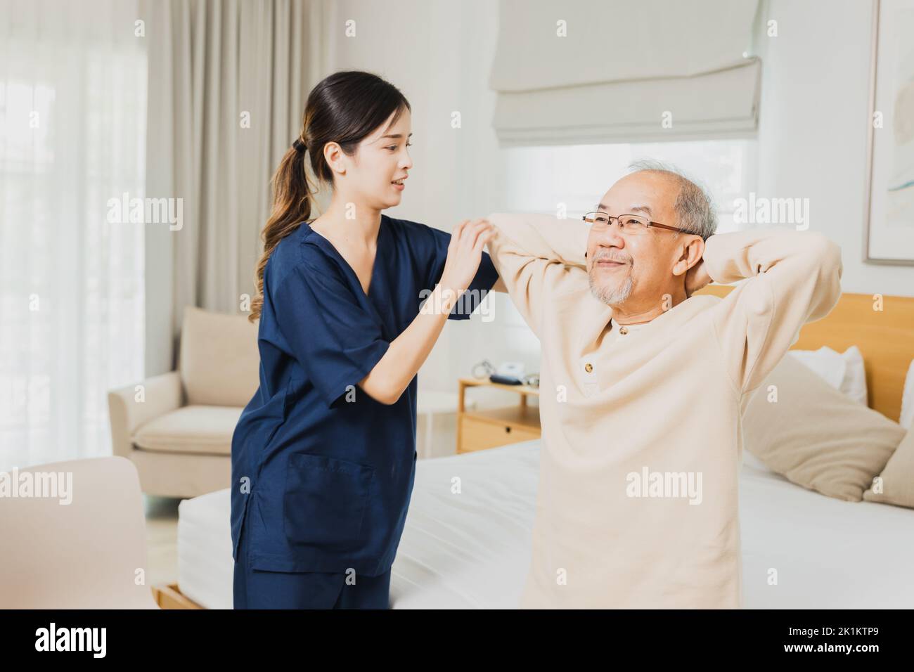 Asian Nurse Woman Assisting Old Man Warming Up Exercises For The Upper Body Inside The Nursing