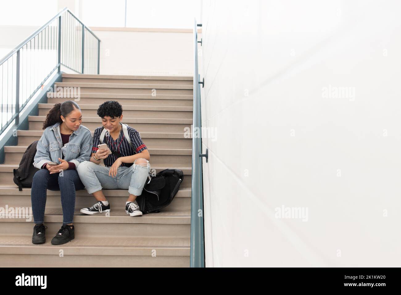 Two girls sitting on stairs hi-res stock photography and images - Alamy