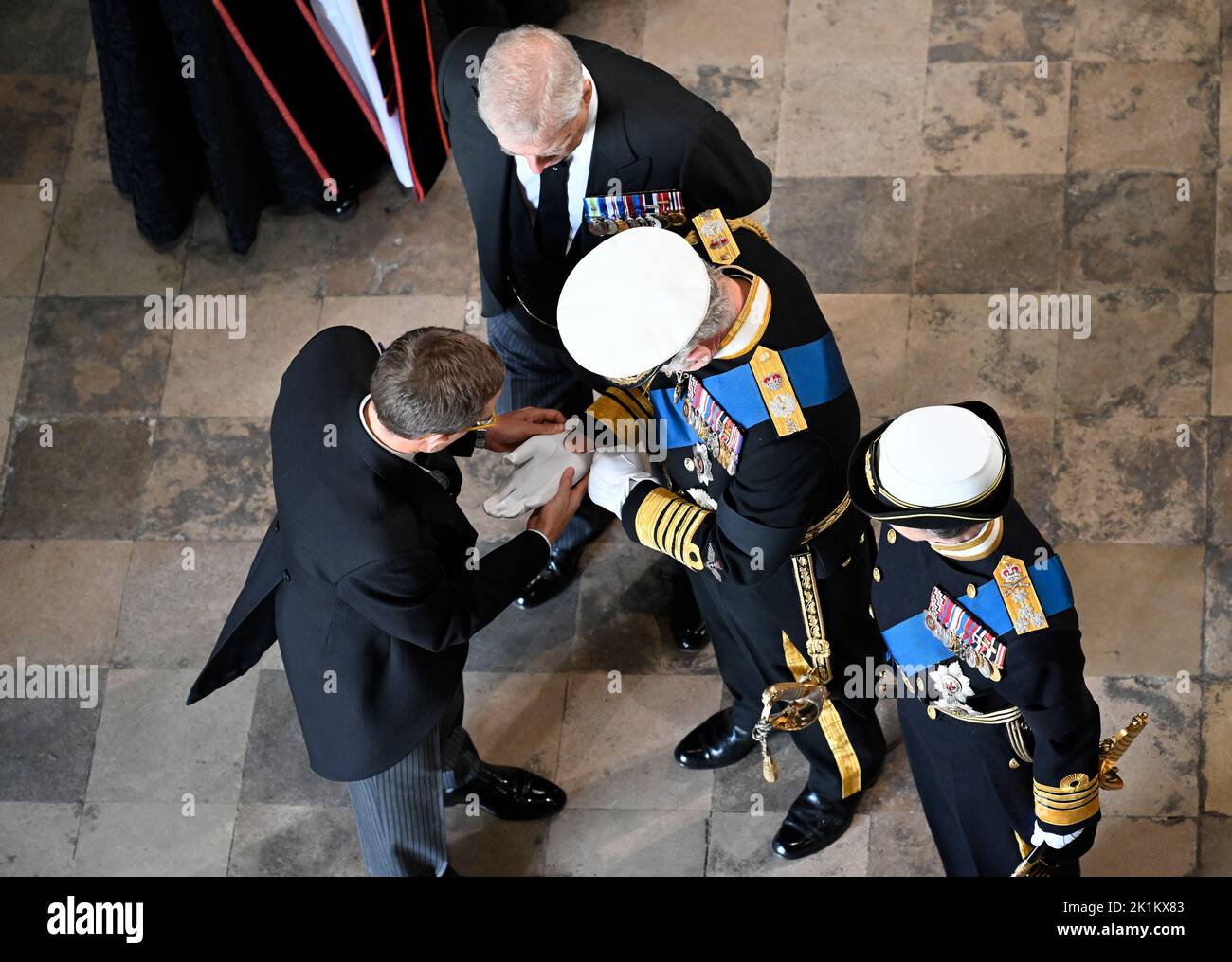 King Charles III has his gloves adjusted during the State Funeral of ...
