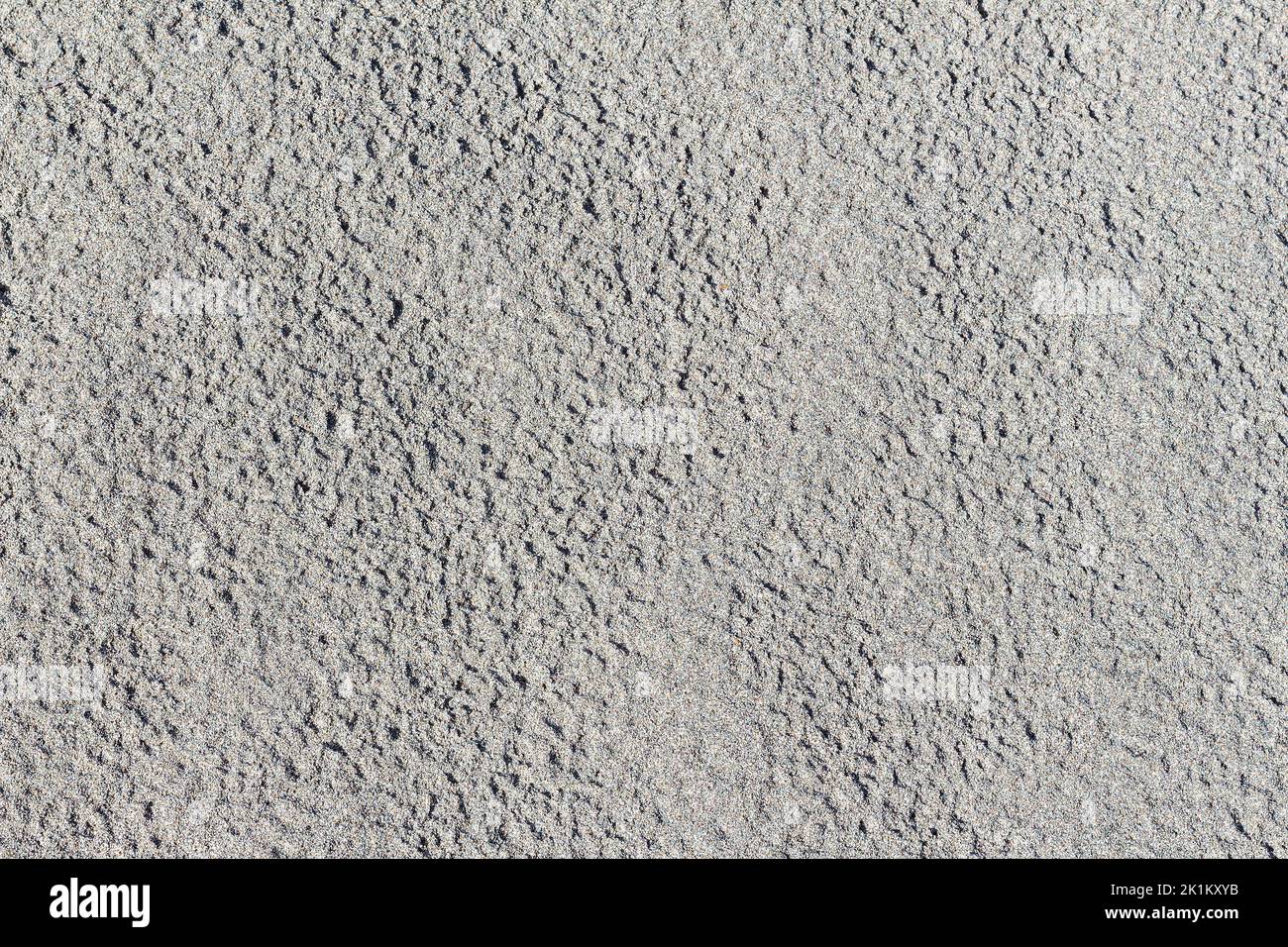 Texture smooth layer of gray neutral sand with traces of drops after ...