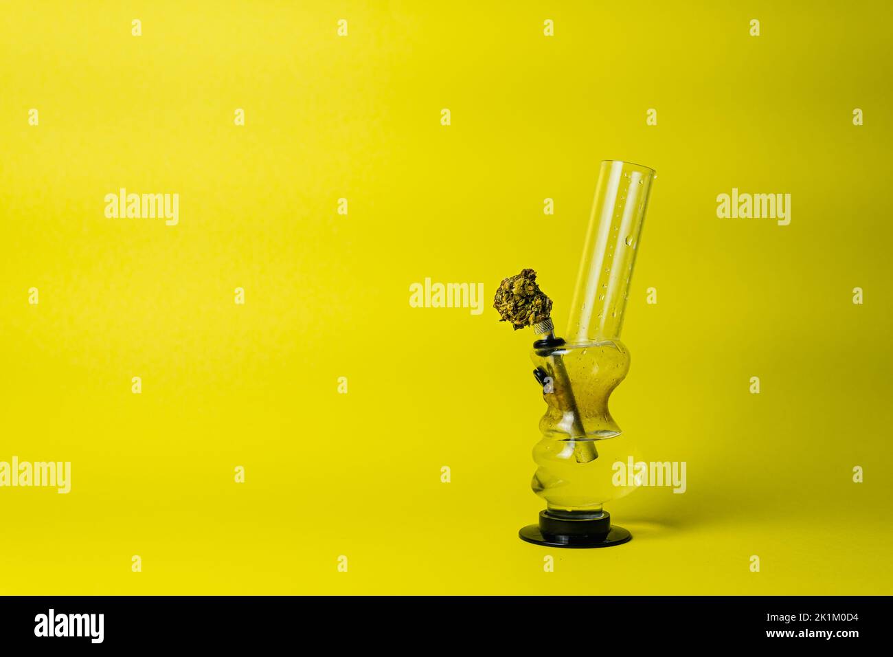 Marijuana bud and bong on yellow background, close up. Concept of ...