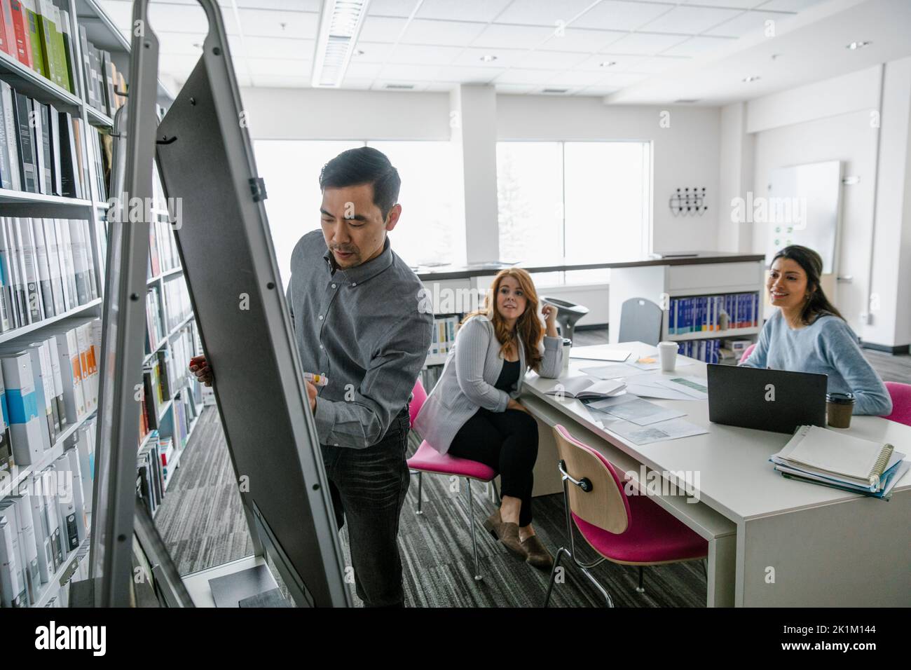 Man using whiteboard in creative office Stock Photo - Alamy