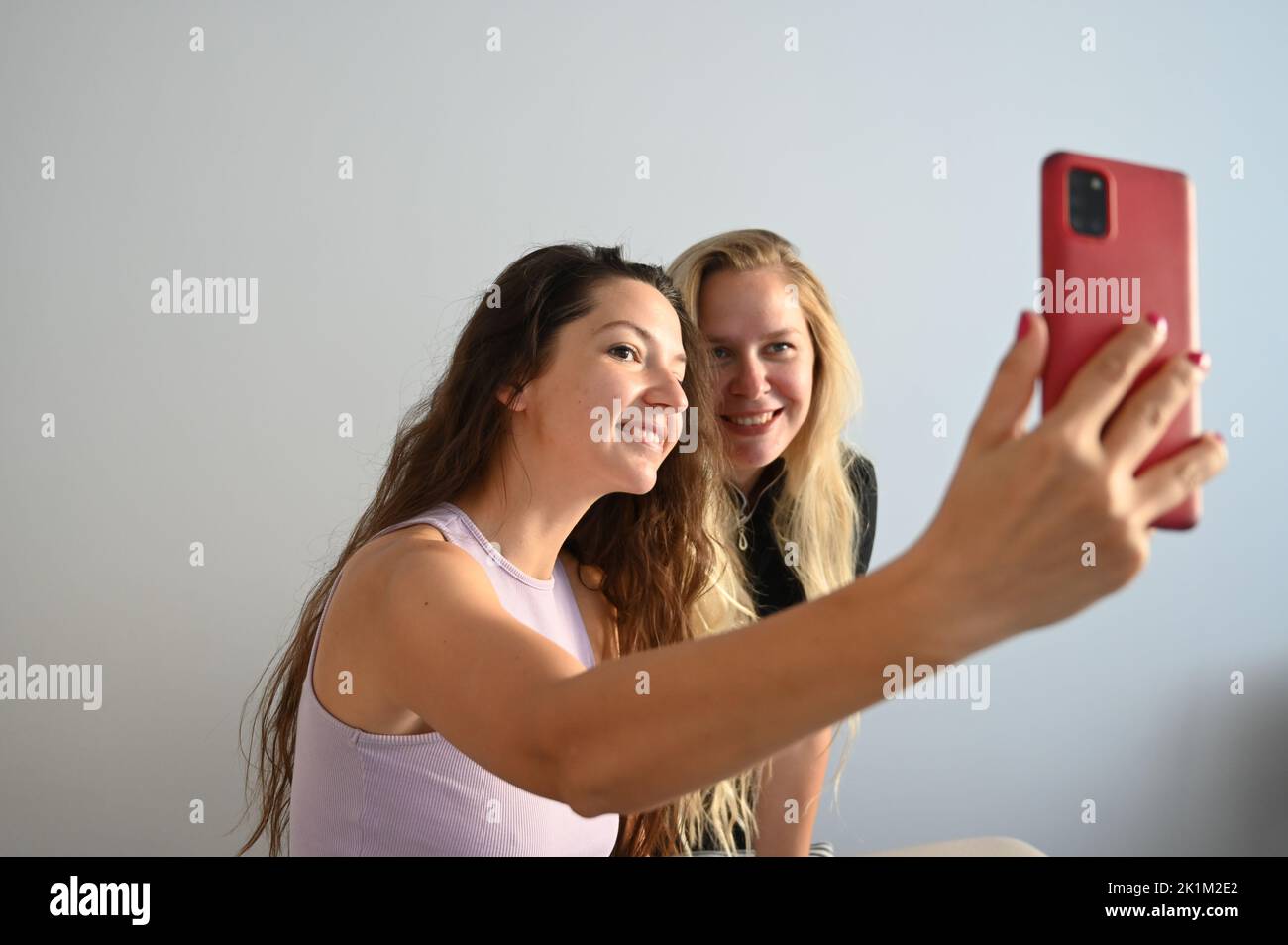 Young Smilling Women Making Selfie On The Light Room Portrait Of Two