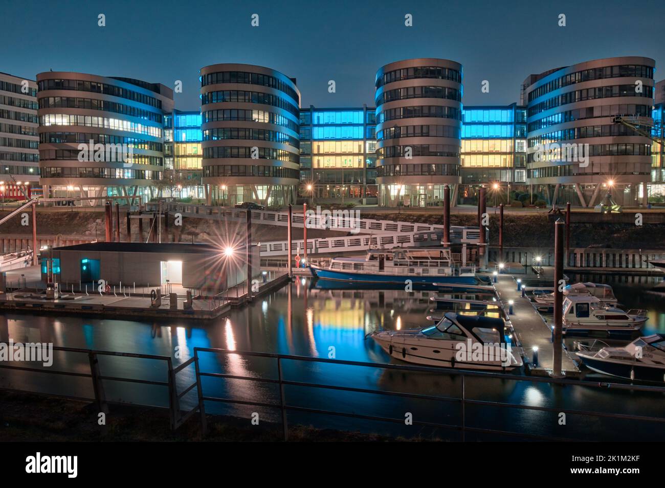 The view of Duisburg harbor buildings illuminated in the colors of the ...