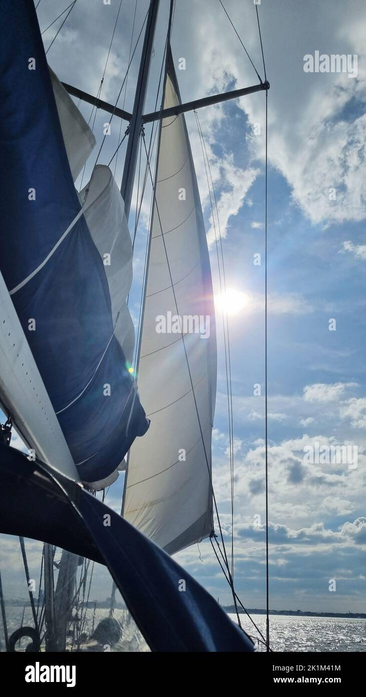 Sailing yacht boat on seawater at sunrise with sun flare and outdoor ...