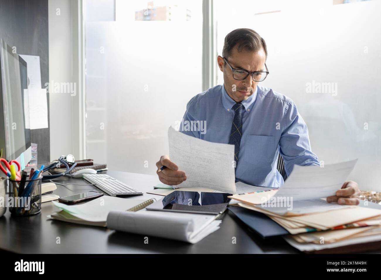 Doctor reading medical charts hi-res stock photography and images - Alamy
