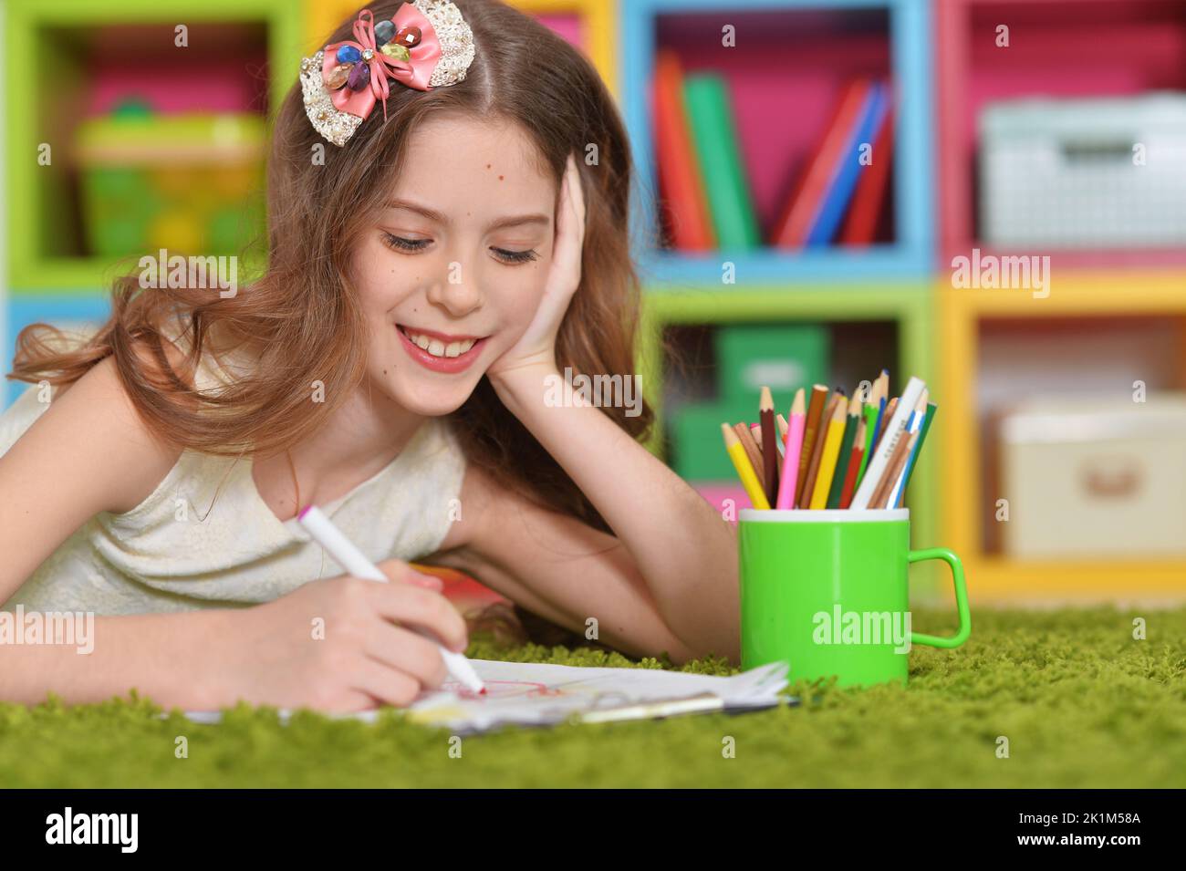 Beautiful little girl draws with a pencil on a sheet of paper Stock ...