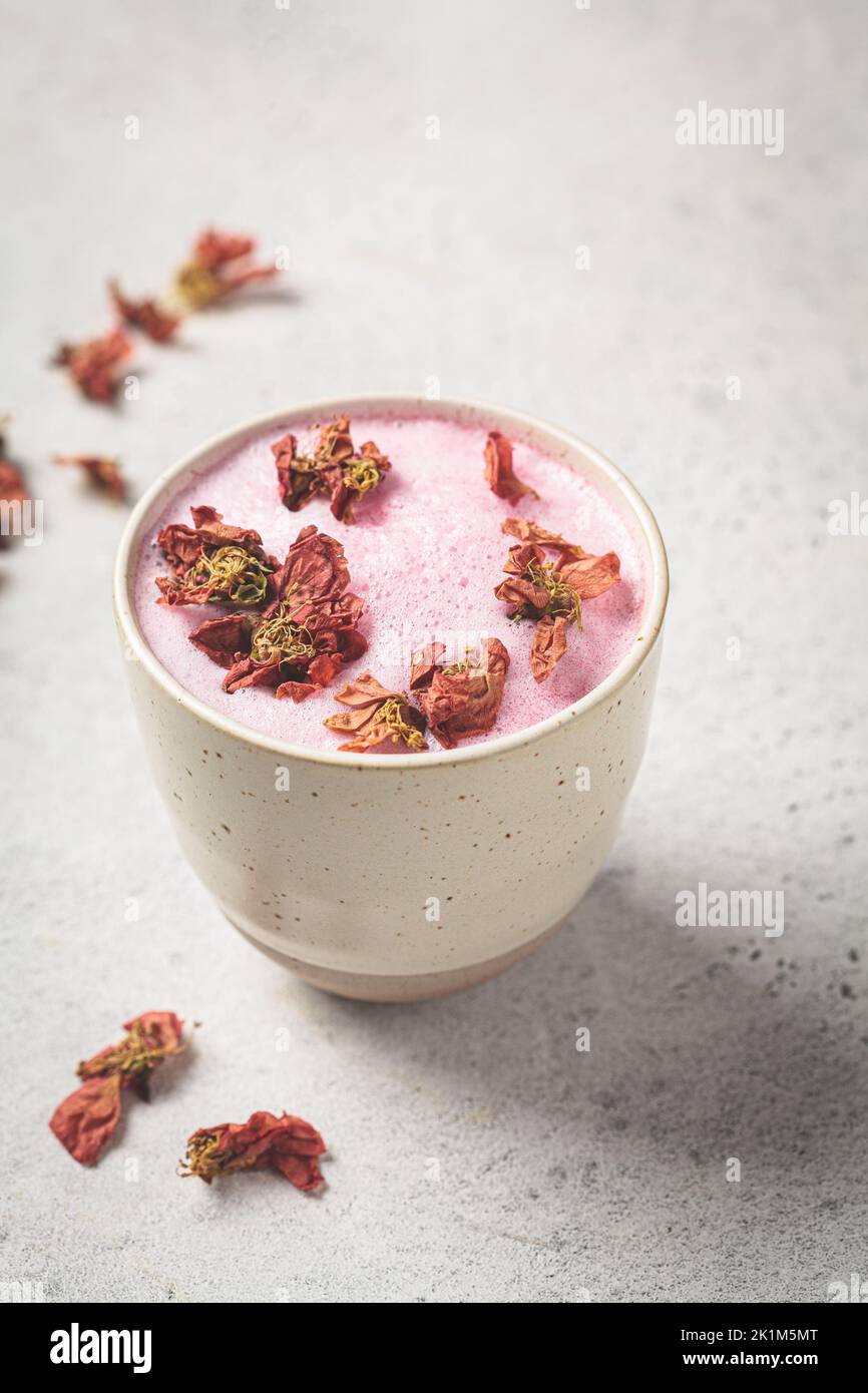 Pink flower moon milk in a white cup. Ayurveda drink, healthy lifestyle ...