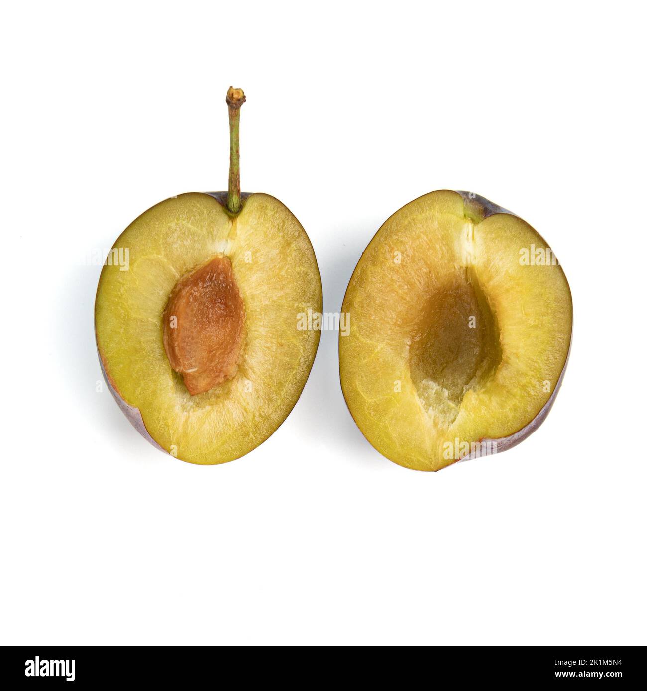fresh ripe cut plums isolated on white background, broken fruit in half ...