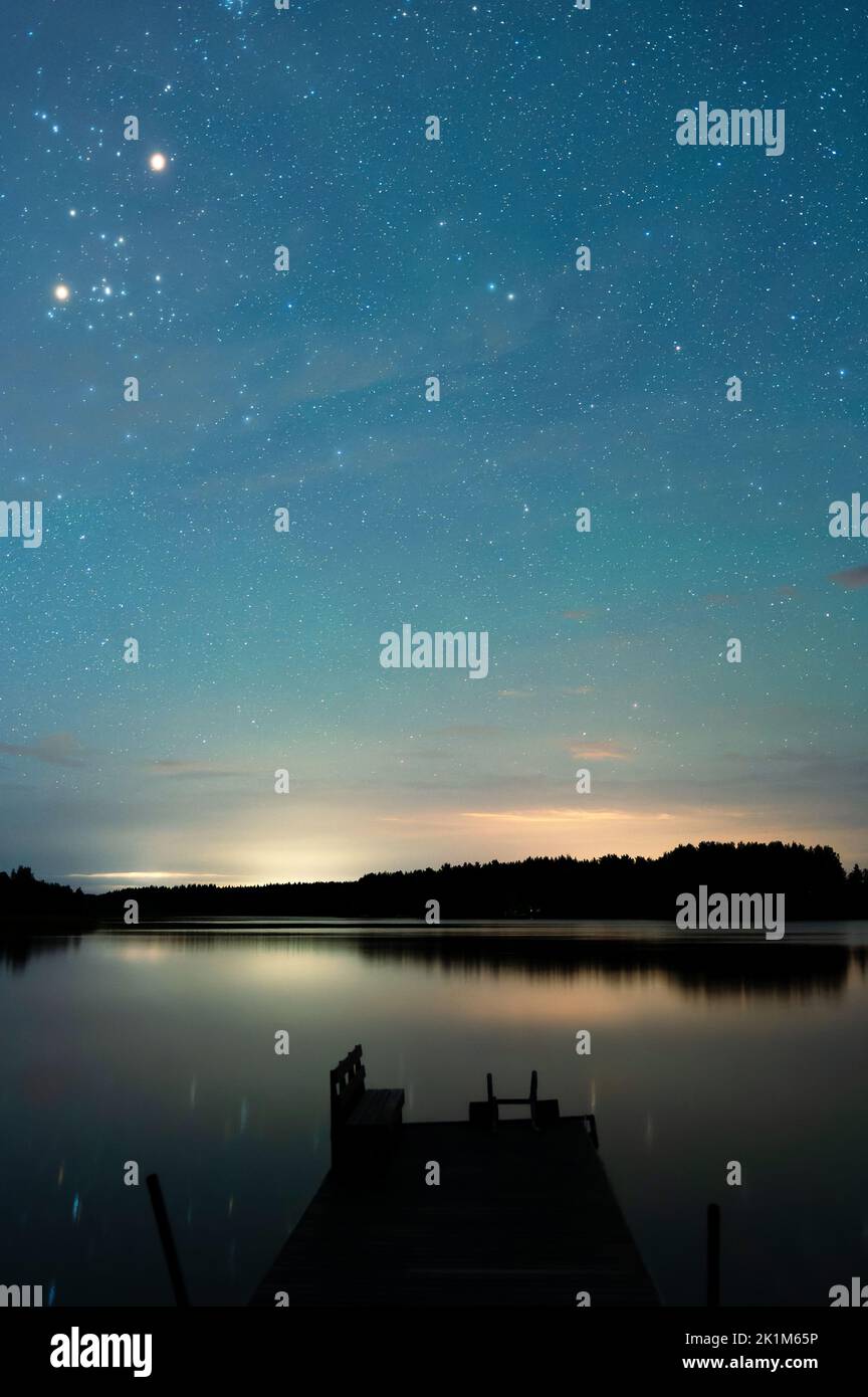 Autumn night landscape under starry sky. Stars reflecting from calm ...