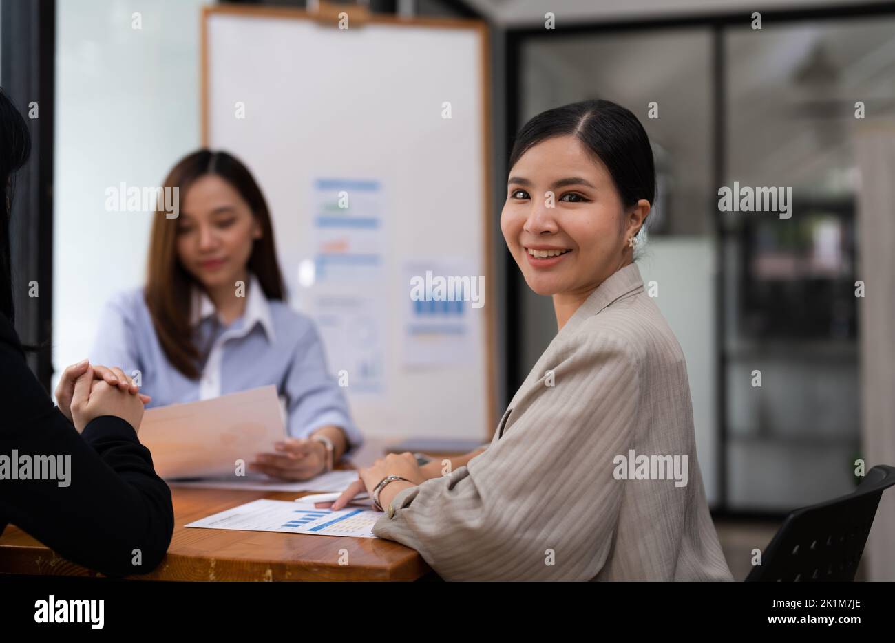 A young asian woman is having a business meeting with her team ...