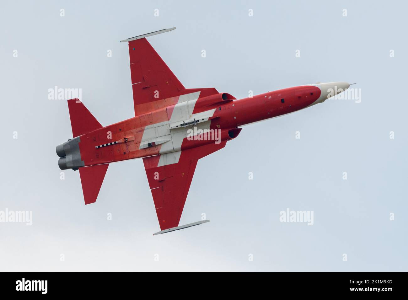 A red jet airplane of the Swiss Airforce performing stunts during an ...