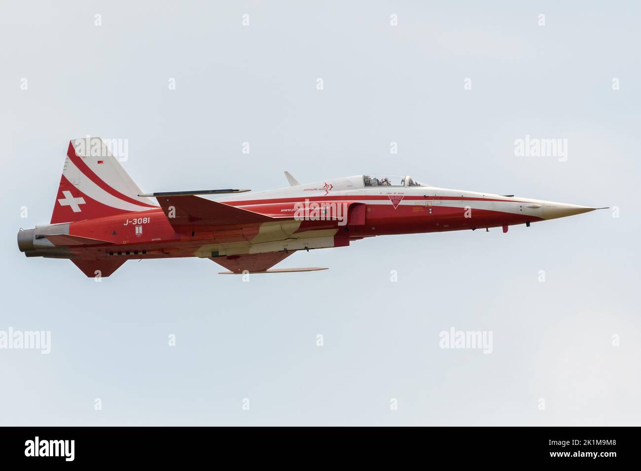 A red jet airplane of the Swiss Airforce performing stunts during an ...
