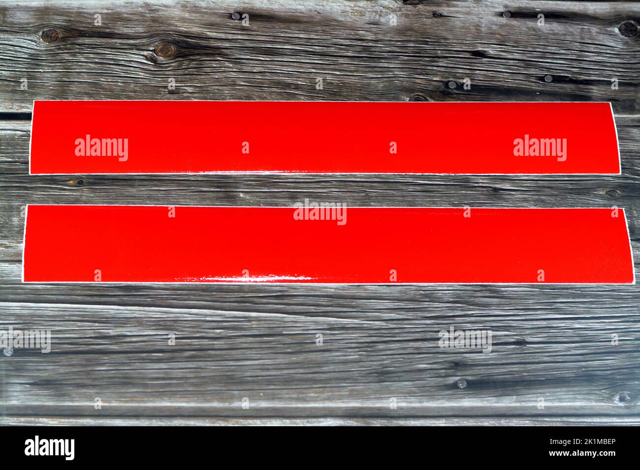 A pair of car phosphorescent reflective stickers isolated on wooden ...