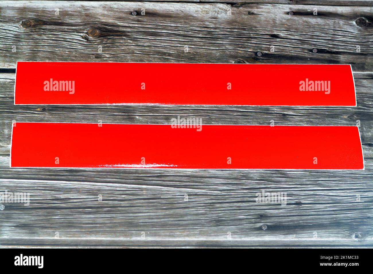 A pair of car phosphorescent reflective stickers isolated on wooden ...