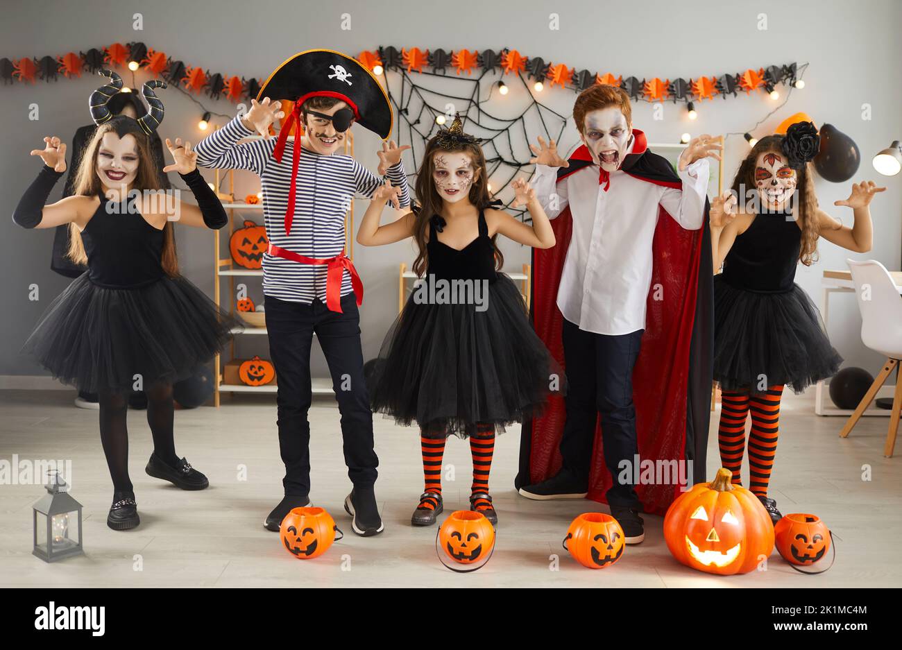 Group of happy children dressed up in spooky costumes having fun at ...