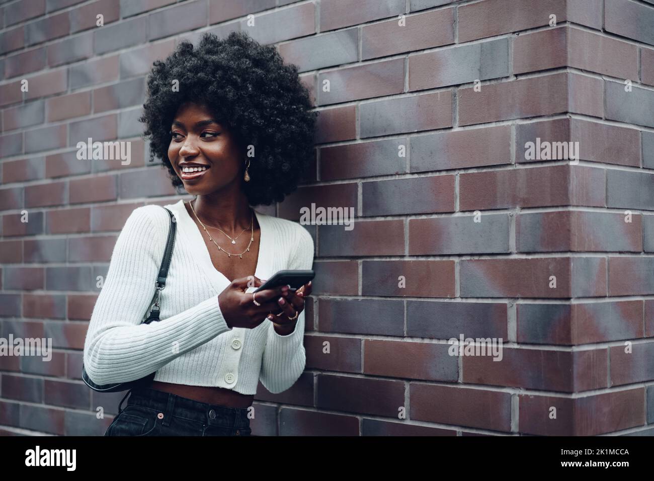 Beautiful young african woman using mobile phone in the street Stock ...