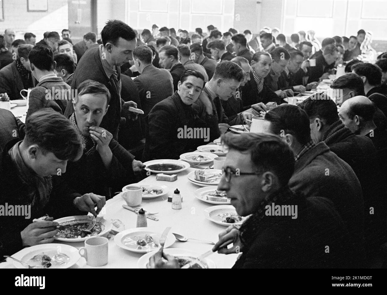 1930s, historical, large group of male mill workers having lunch ...