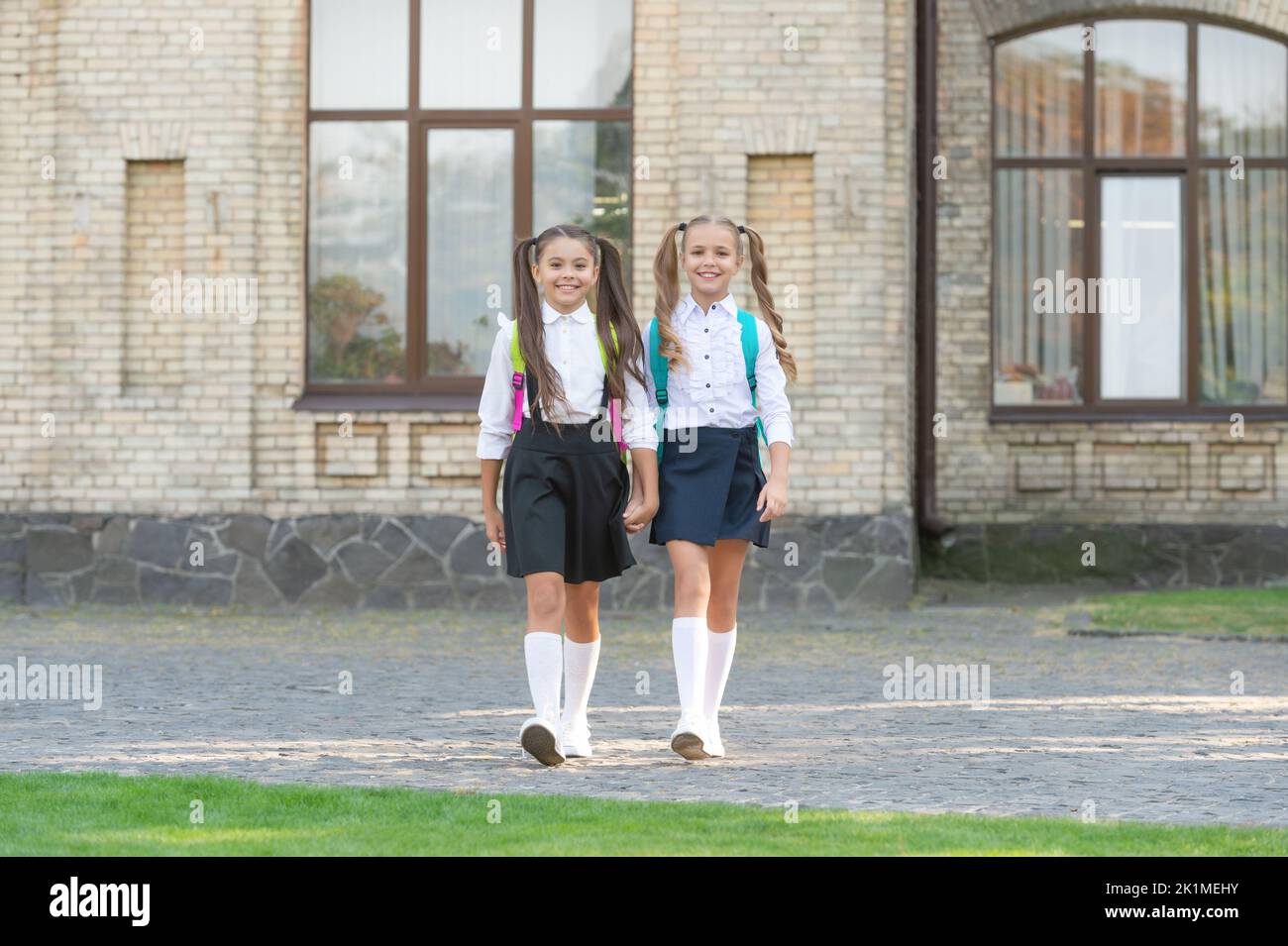 two schoolgirls in uniform walking together outdoor Stock Photo - Alamy