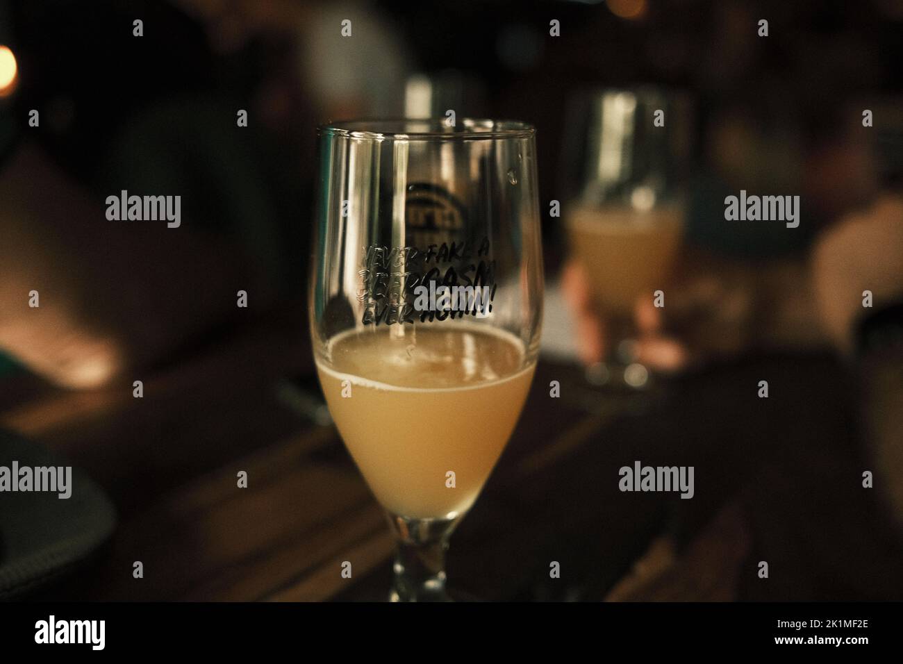 The close-up view of a craft beer in a port glass on the bar counter ...