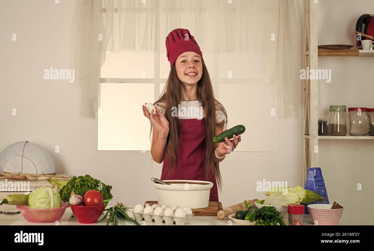 Food in your budget. kid chef cooking with cucumber and egg. child prepare healthy food at home ...