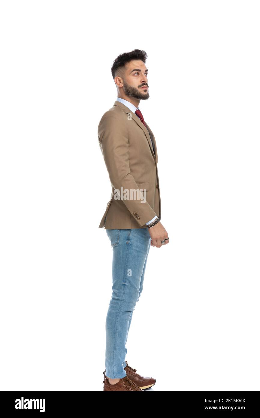 side view of thoughtful young man looking up and thinking while ...