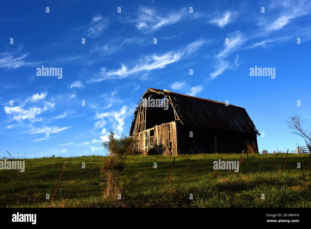 Dusk settles over hillside barn. The last of the sunlight captures the ...