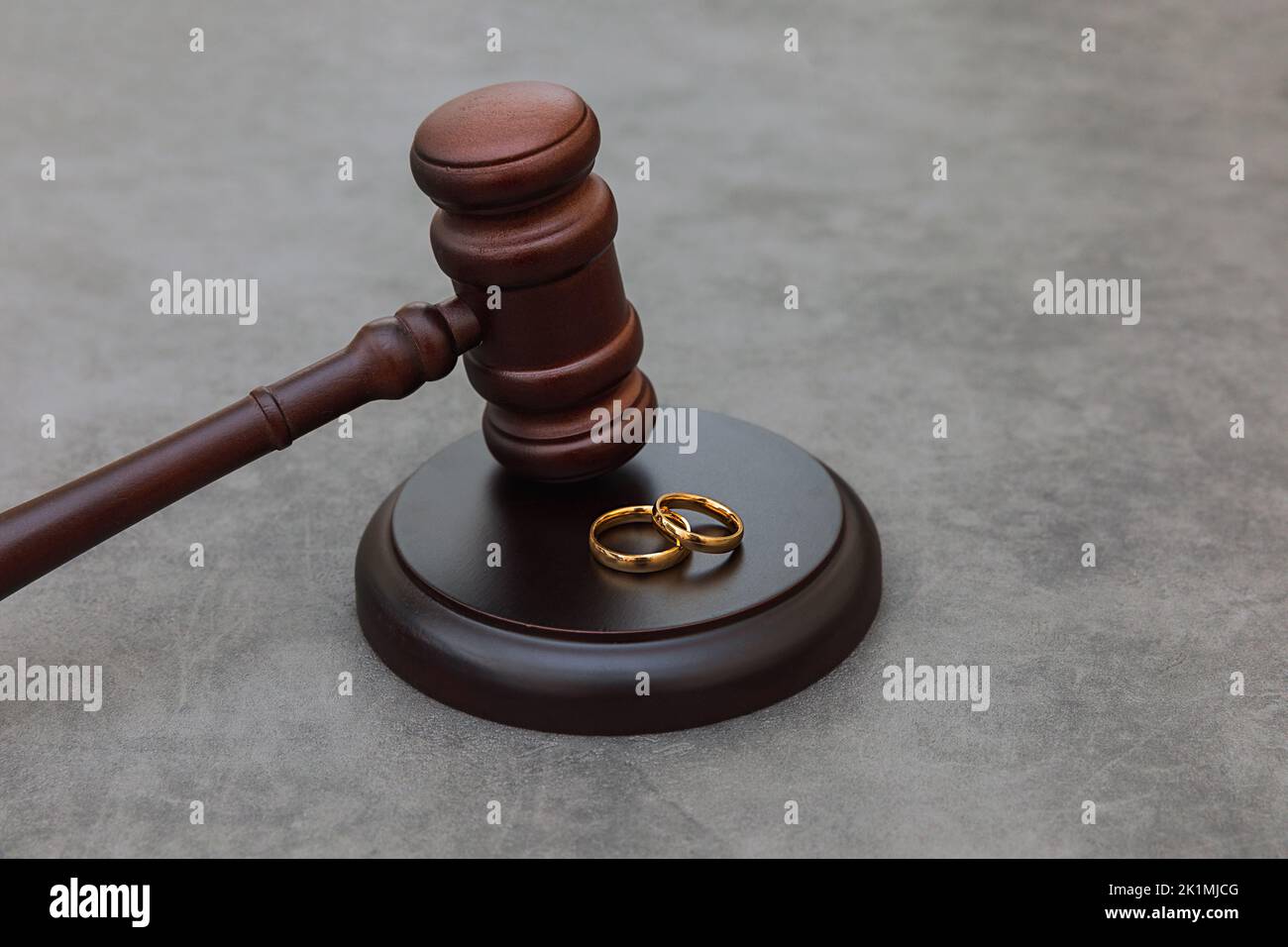 Law theme. Judge gavel wedding rings on concrete stone grey background ...