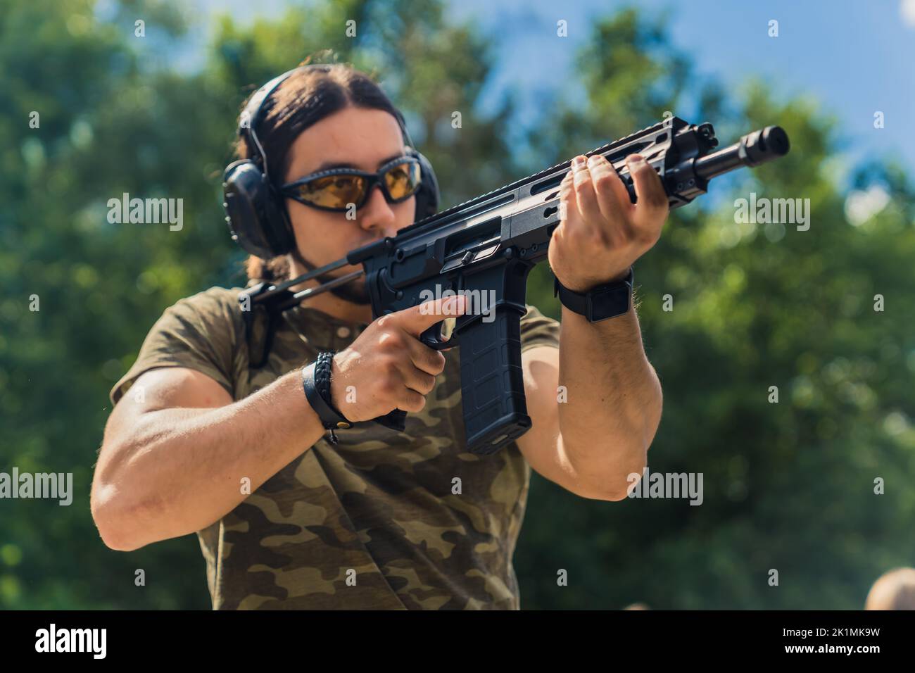 middle-aged European man practicing at the outdoor shooting range ...
