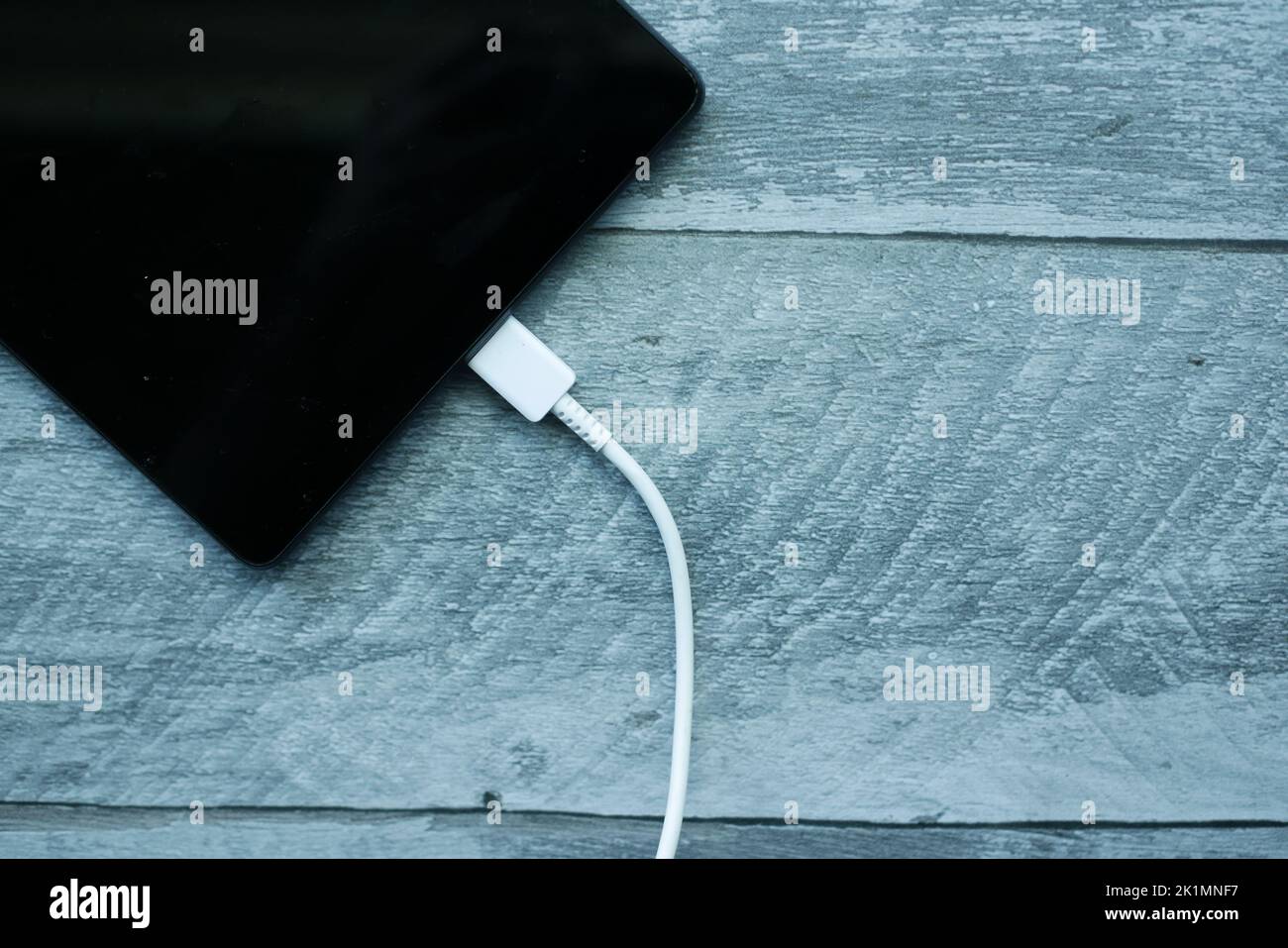 charging s digital tablet with a cable on white background Stock Photo ...