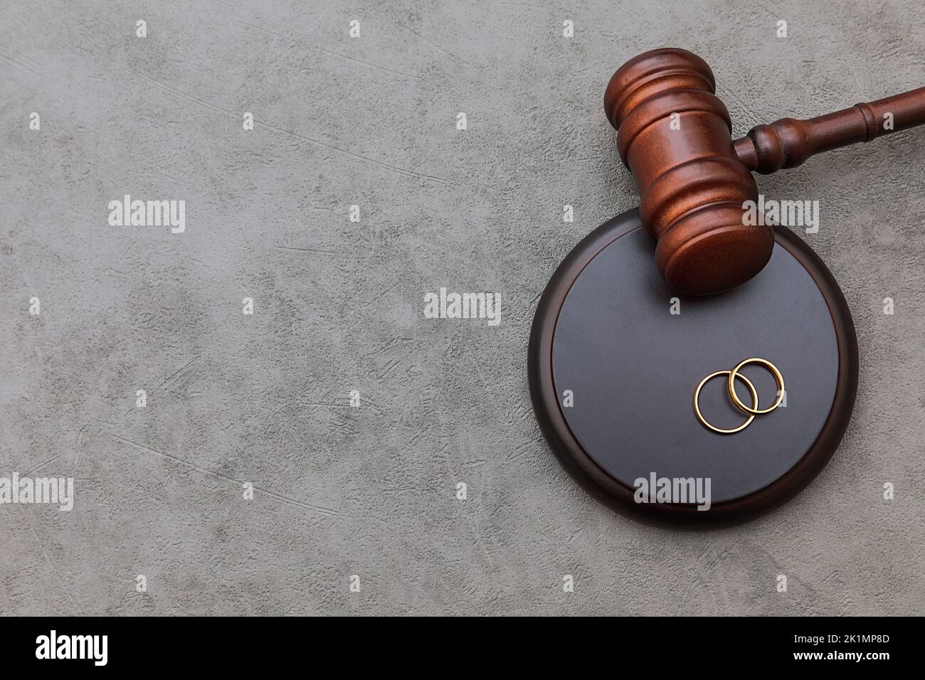 Law theme. Judge gavel wedding rings on concrete stone grey background ...