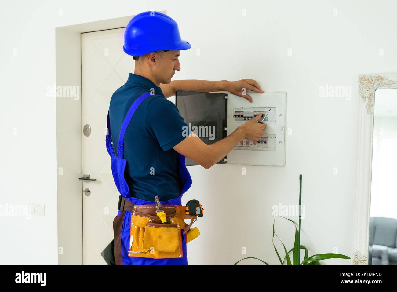 Electrician Builder at work, examines the cable connection in the ...