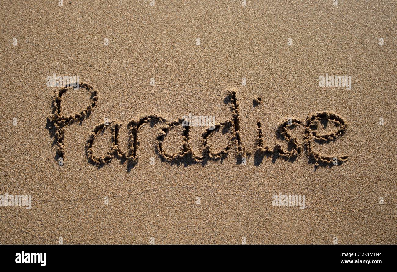 The word "Paradise" written in the sand on a beach in Cyprus Stock ...