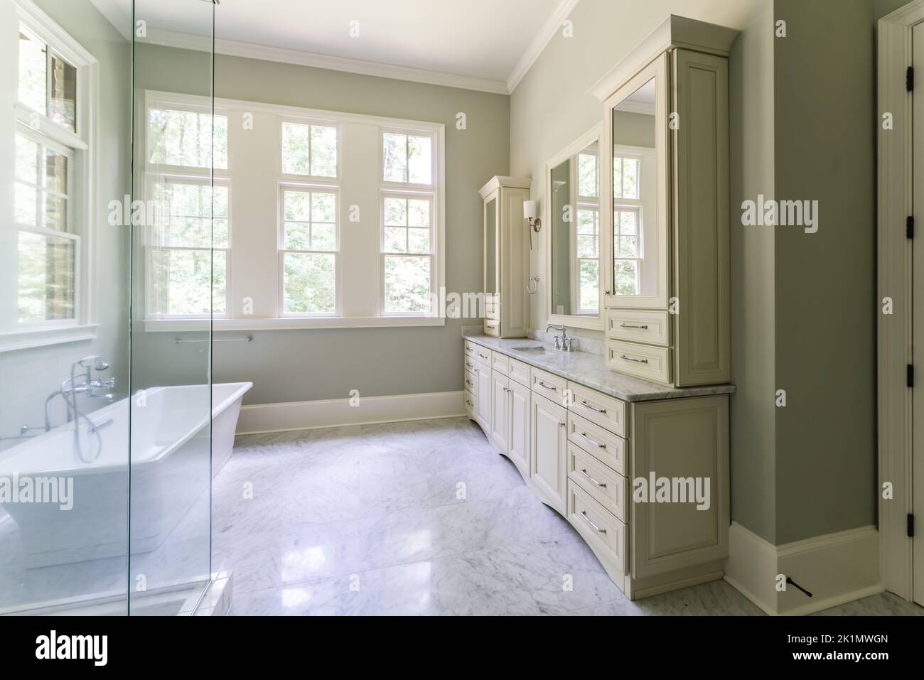 Sage green bathroom with dover white trim, standalone tub, shower enclosed with glass featuring ...