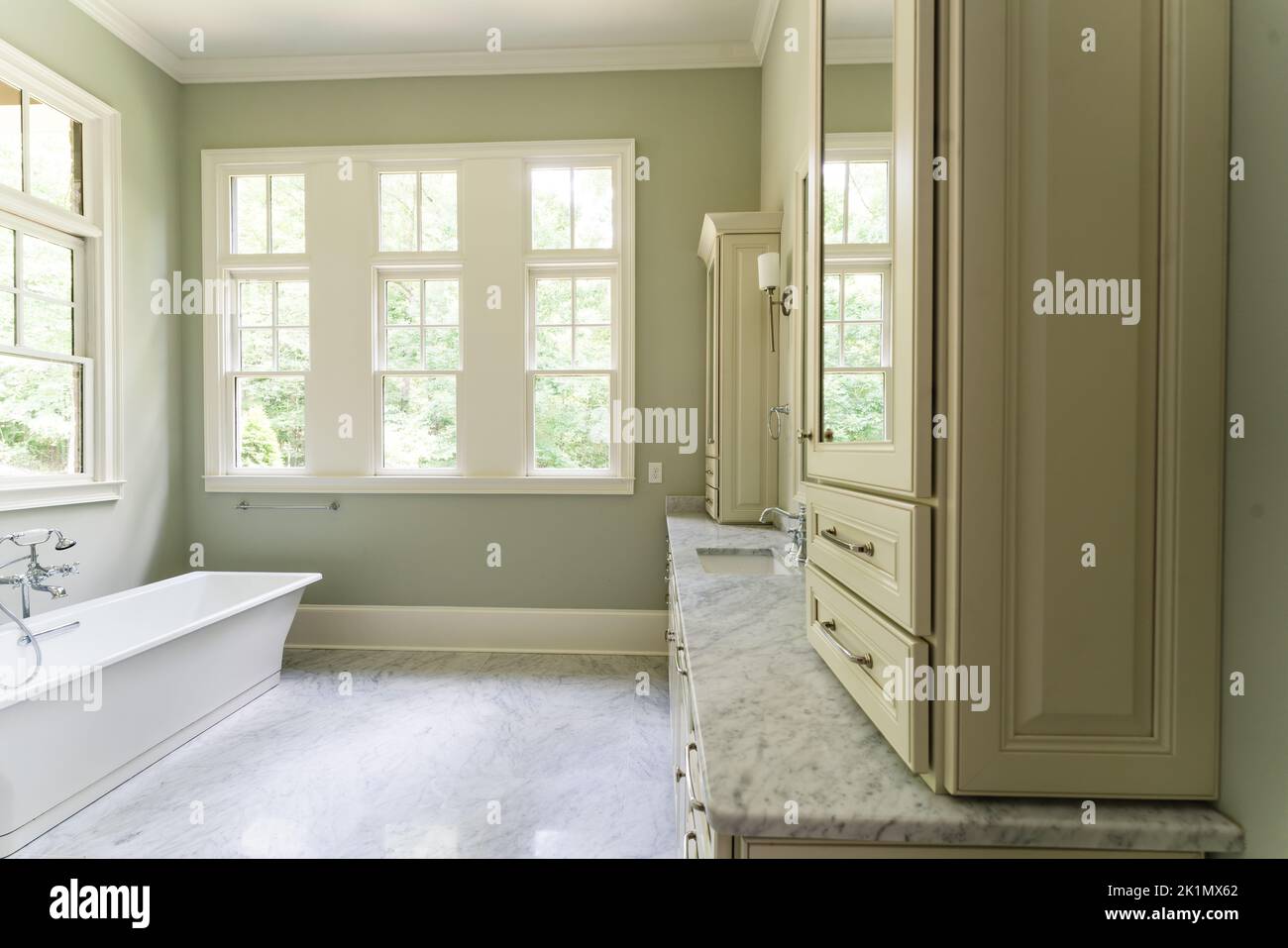 Sage green bathroom with dover white trim, standalone tub, shower enclosed with glass featuring ...