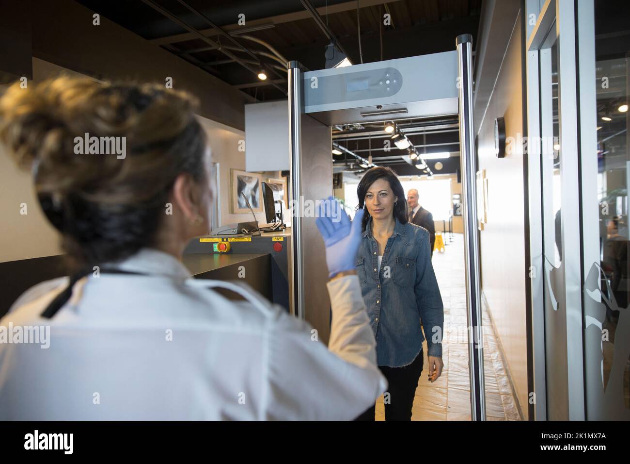 Airport security agent guiding female traveler at checkpoint Stock ...