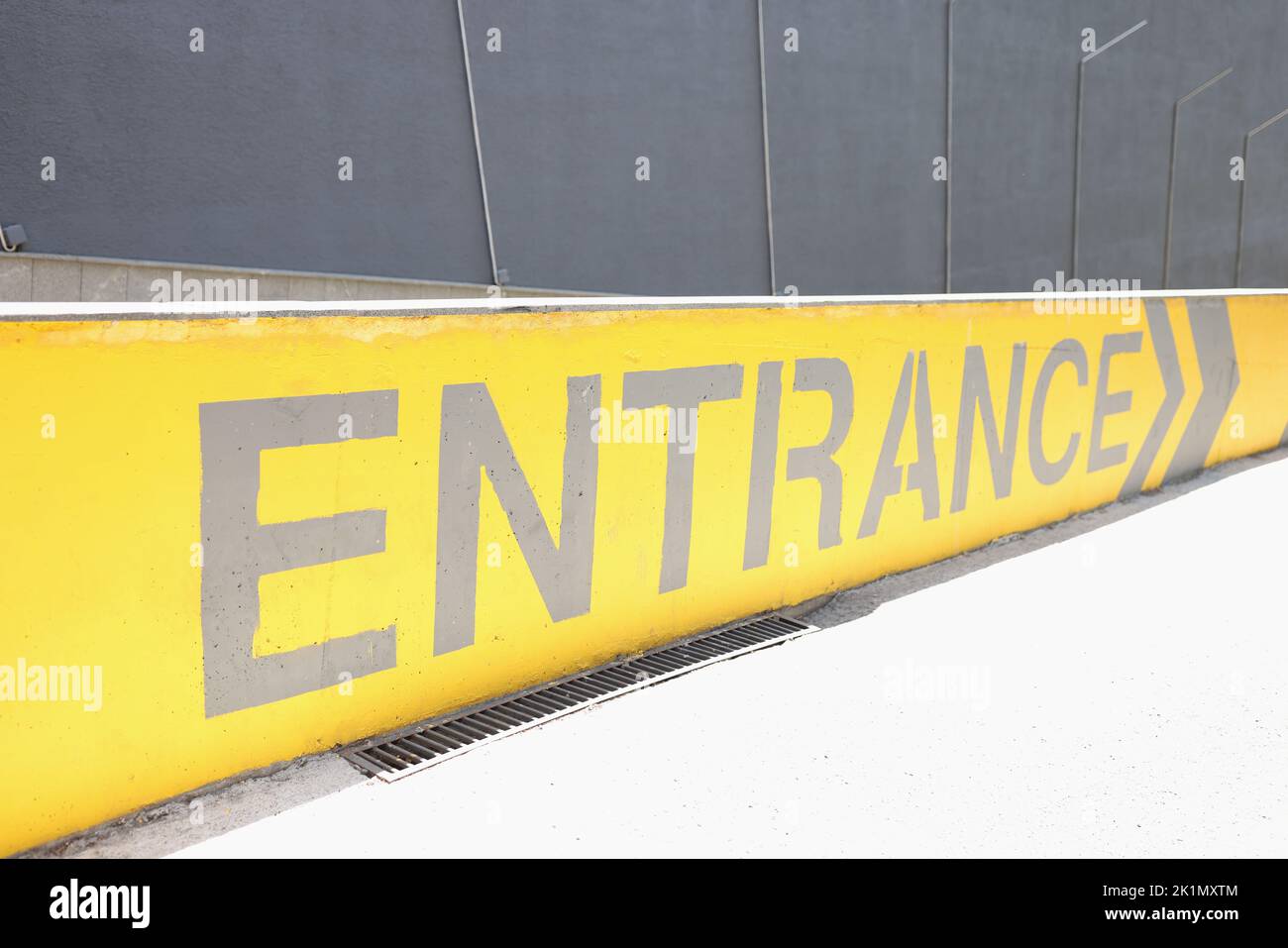 Closeup of arrow sign and inscription entrance on wall Stock Photo - Alamy