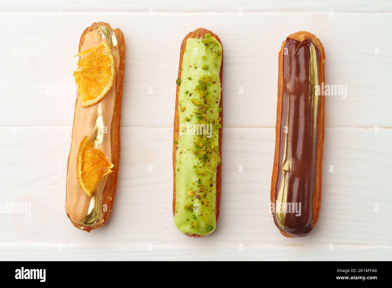 Beautiful french eclairs set on white wooden background Stock Photo - Alamy