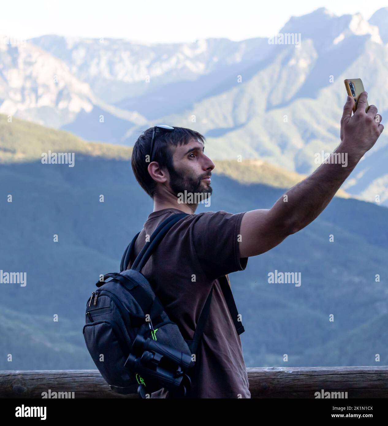 guy with beard wearing backpack with binoculars taking a selfie Stock ...