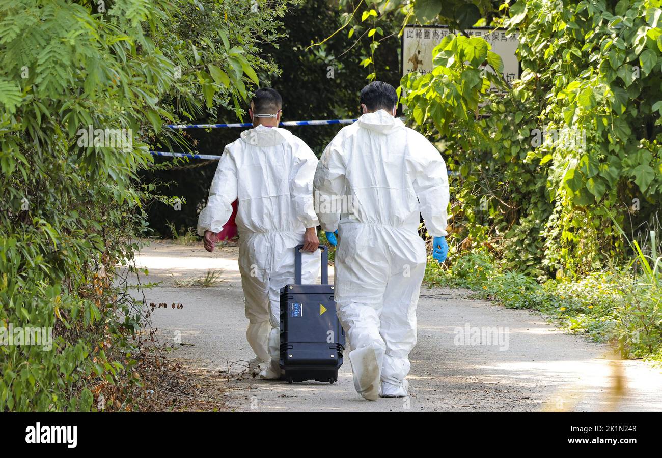 Police officers search at the site for the body of the victim at a ...