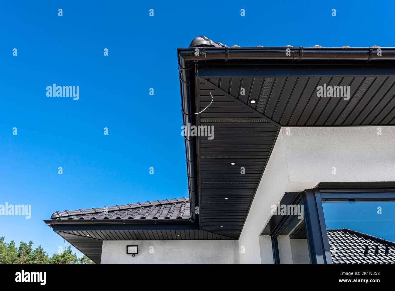 A modern graphite herringbone roof lining is attached to the trusses ...