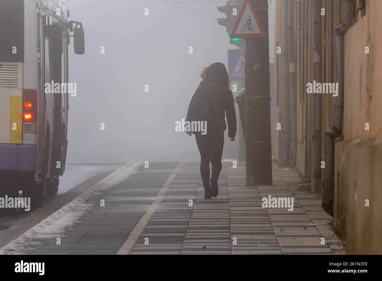 Woman walking on the street on a foggy day. Real people Stock Photo - Alamy