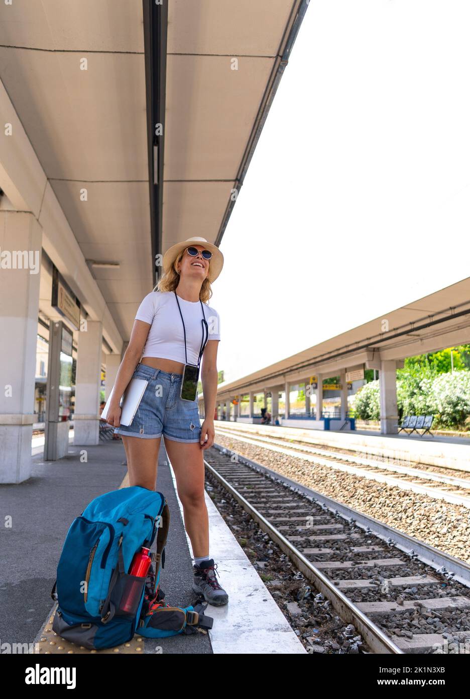 Girl waits for train at station for her next destination, wearing a ...