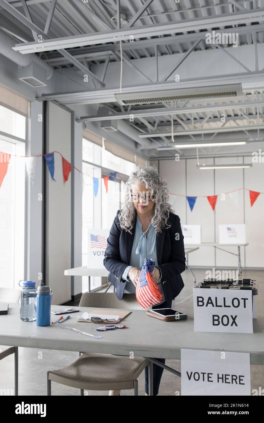 Woman holding American flags on voting day at polling place Stock Photo ...
