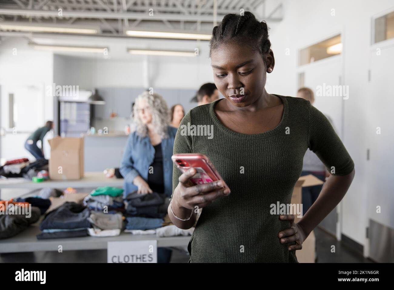 Female volunteer with smart phone in community center Stock Photo - Alamy