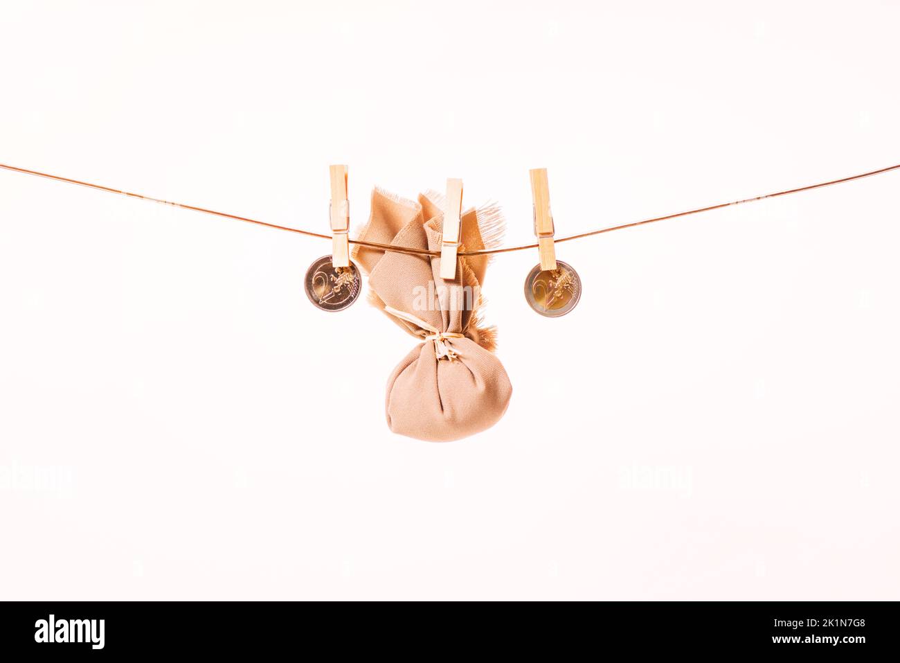 Coins on a rope on a white background, euro bills, hung by wooden ...