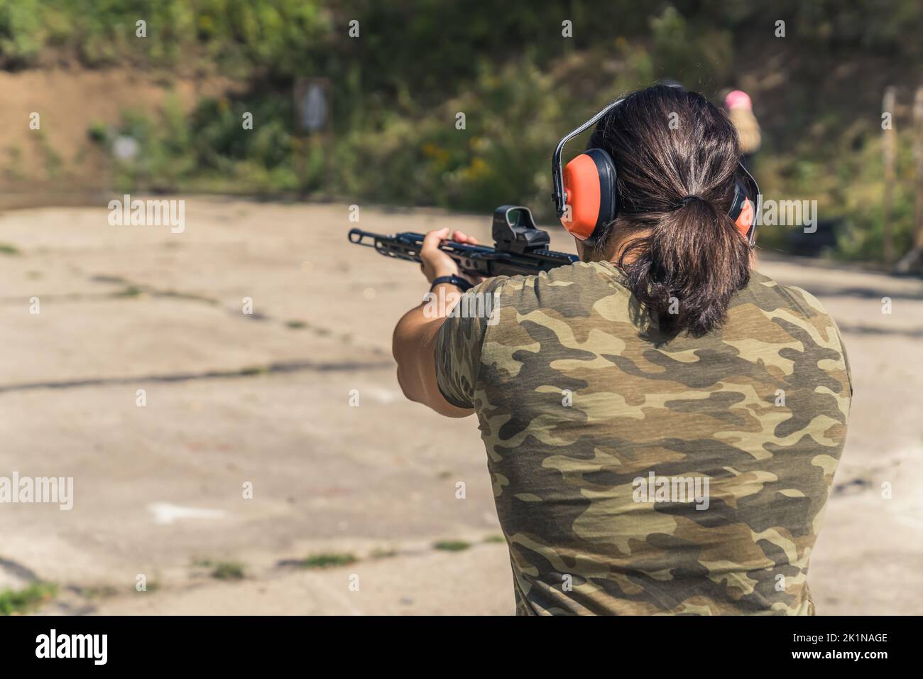back view of a man practicing aiming at the shooting range and holding ...