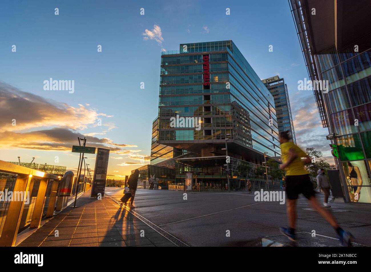 Wien, Vienna: Strabag Headquarters in Donaucity, pedestrians at sunset ...