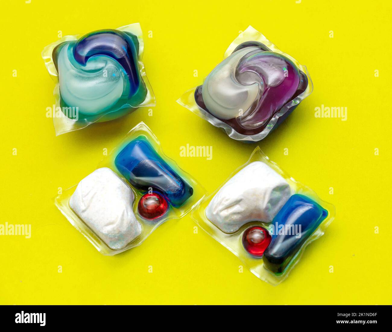 Colorful detergent plastic pods on yellow background used for domestic ...