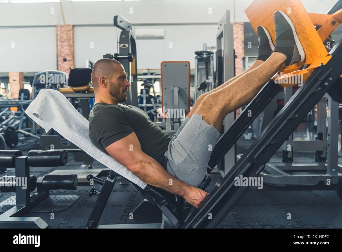 man doing exercise on leg press during fitness training at the gym ...